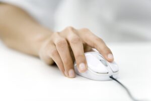Close-up shot of a person's hand using a computer mouse