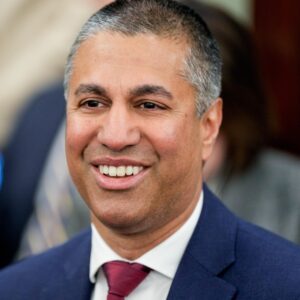 Ajit Pai smiles while attending a Congressional hearing.