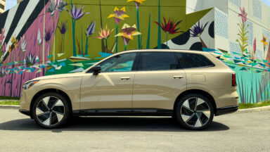 a Volvo EX90 in front of a colorful mural