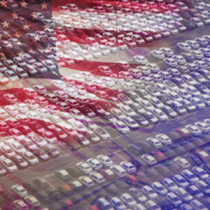 Aerial view of car storage or parking lot new unsold EV cars with an American flag superimposed on top