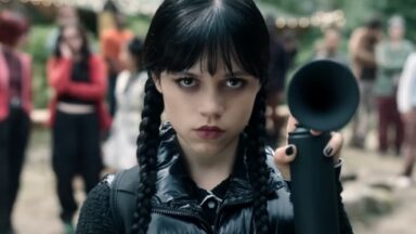 dark haired goth girl in pig tails dressed all in black holding up an emergency horn