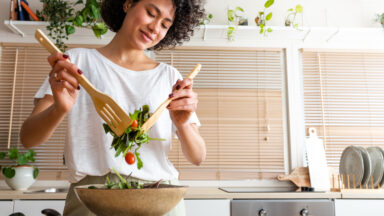 Woman mixing bowl of fresh salad.