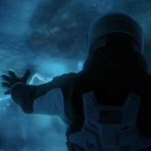 shadowy back of a person in a spacesuit reaching out one hand to a glowing blueish mass in front it them